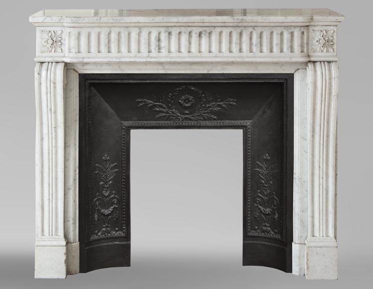 An antique Louis XVI style fireplace with flutes, made out of Carrara ...